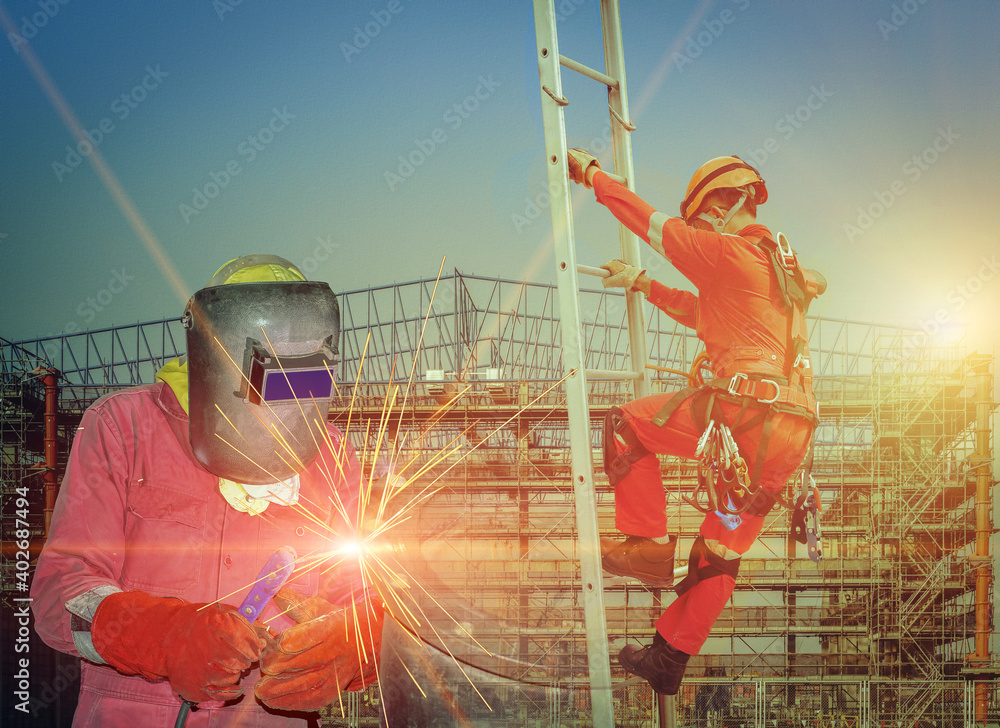 Welding worker in construction with Worker on fixed ladder, wearing ...