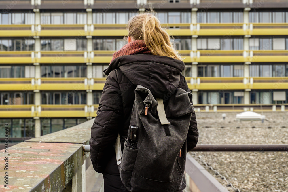 German female student faces one of the buildings of the university ...