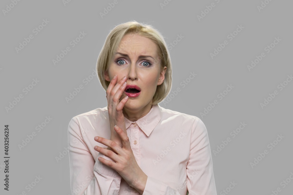 Portrait of young frightened blonde woman. Shocked scared woman holding ...