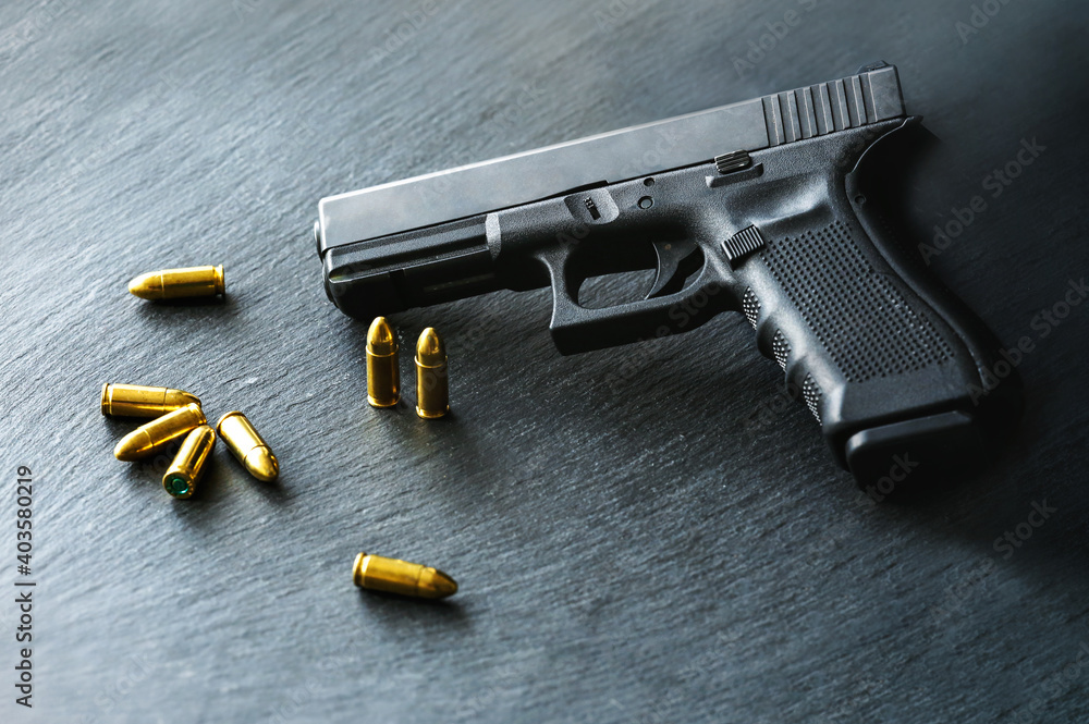 Gun with ammunition on dark stone background. 9mm semi-auto pistol ...
