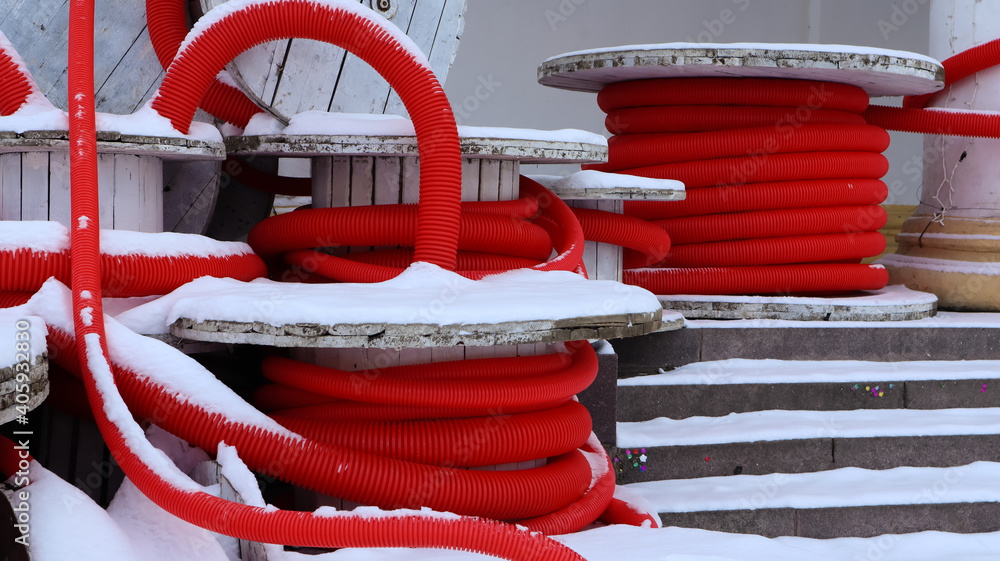 Large coils of red flexible corrugated pipe used to protect cables in ...
