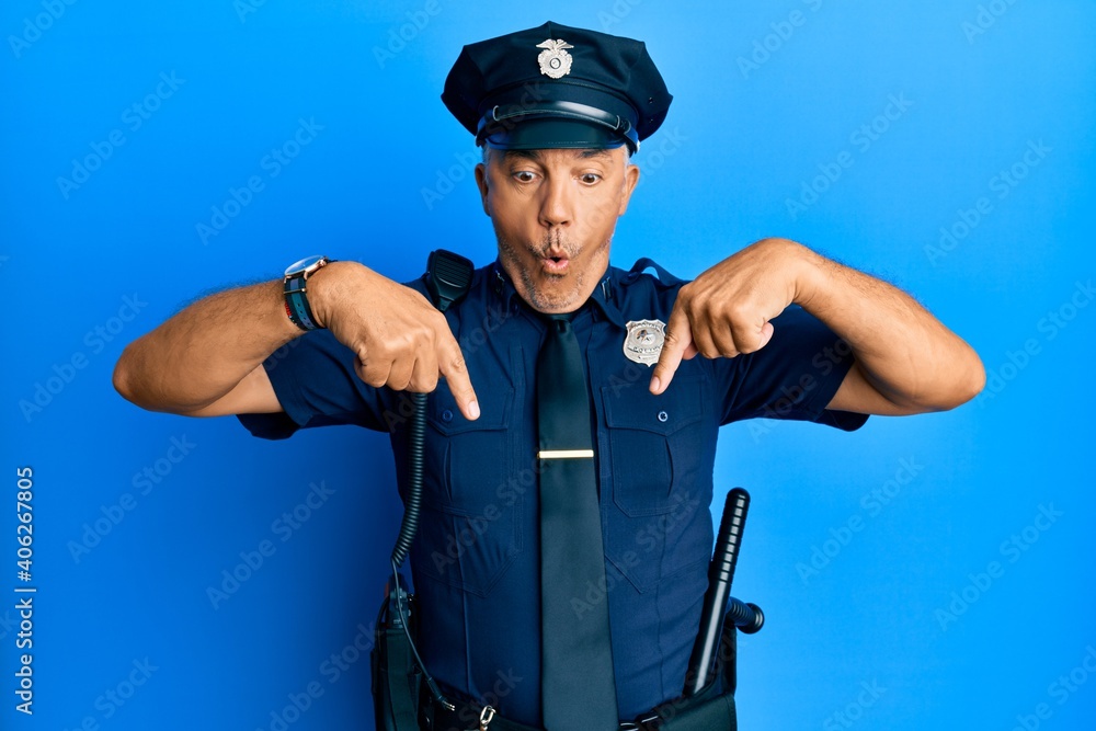 Handsome middle age mature man wearing police uniform pointing down ...