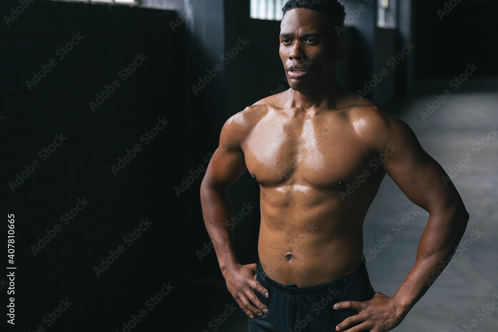 African american man standing and flexing his muscles in empty urban ...