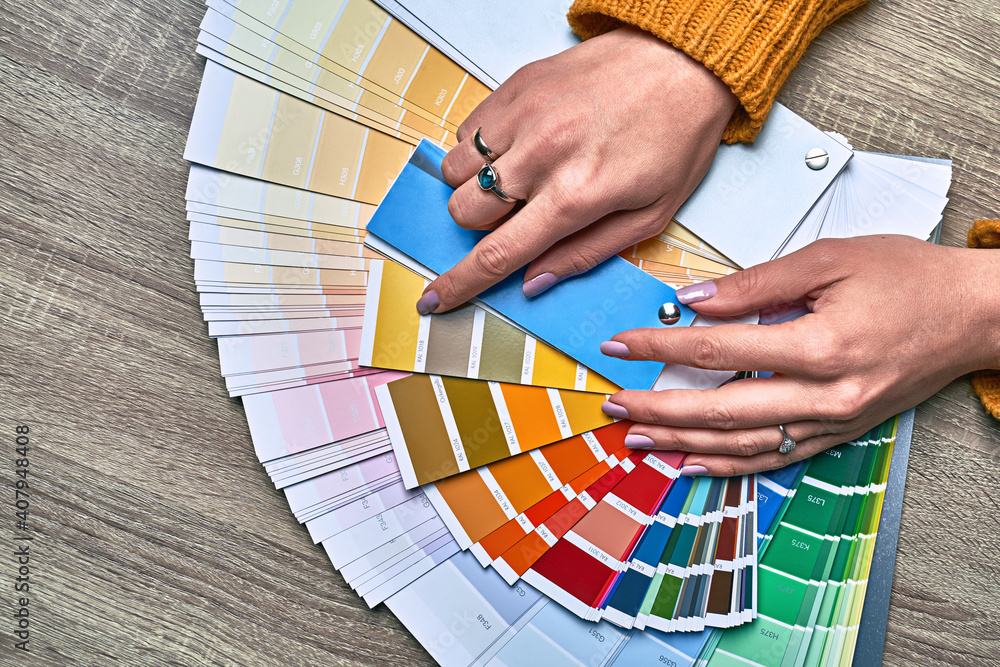 Color wheel for choosing paint tone. Hands of female interior designer ...