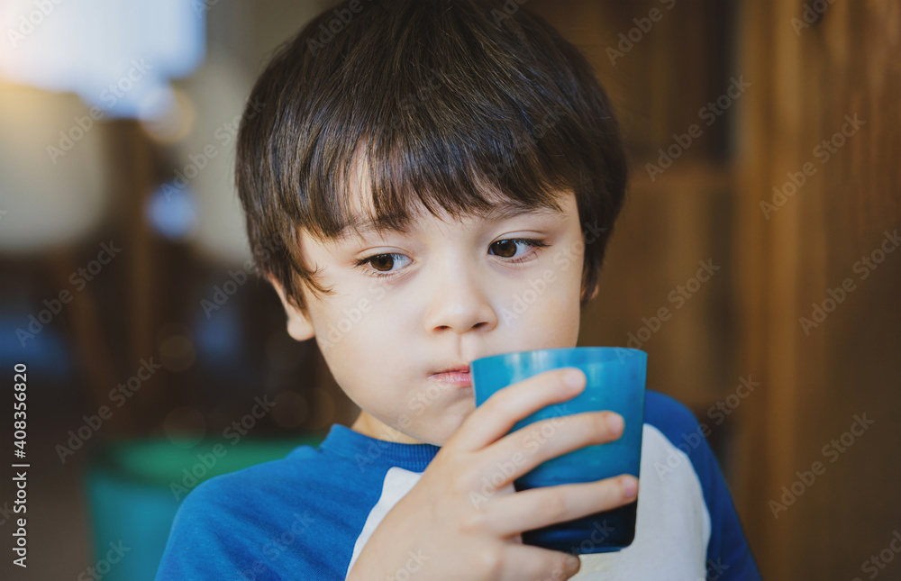 Authentic portrait Kid drinking soda drink in blue glass, Crop shot ...