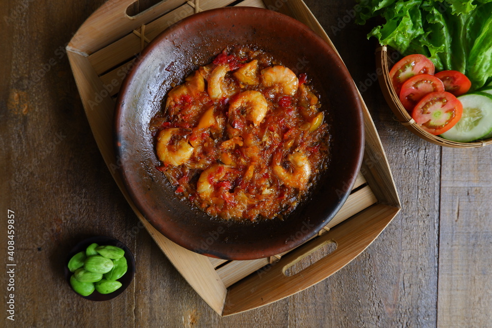a plate of prawn cooked in sambal in an earhenware plate named gami ...