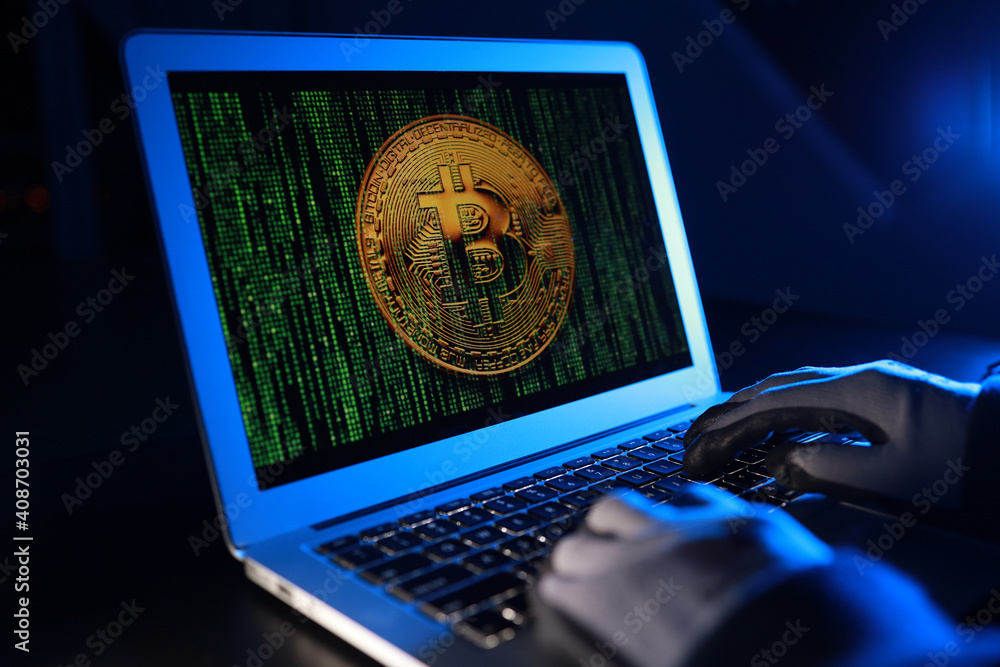 Hacker with computer hacking and stealing data information. Bitcoin logo and binary code as ...
