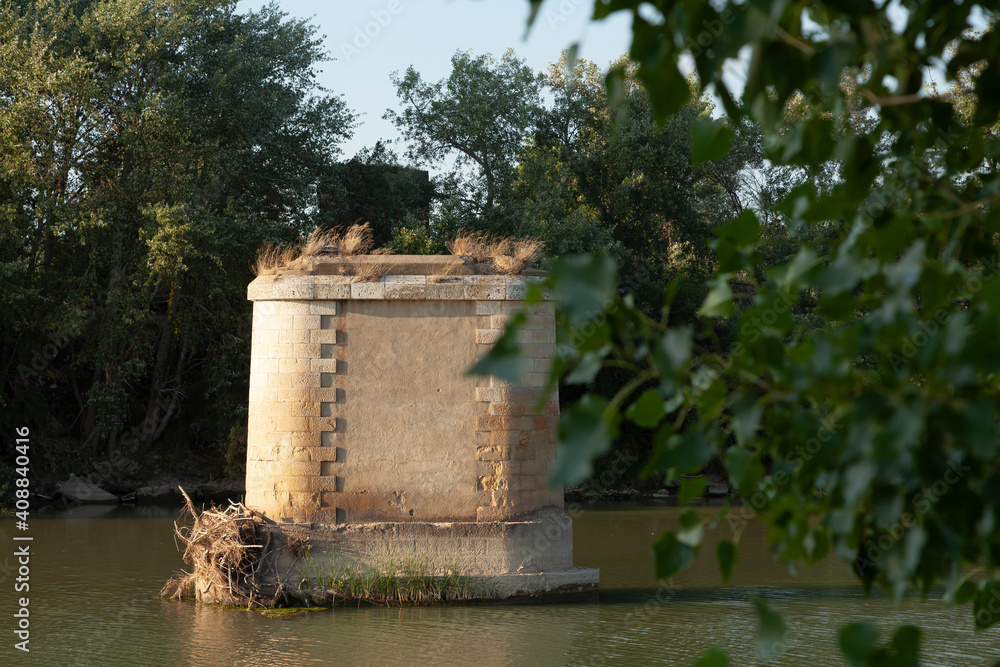 An old support pylon in the middle of the Ebro river, a vestige of the ...