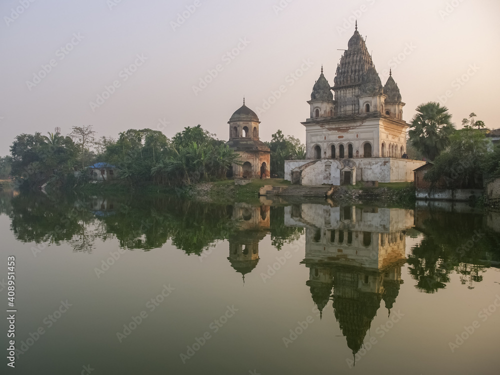 Beautiful ancient Bhubaneshwar Shiva temple at sunset with reflection in Shiv Sagar pond in ...