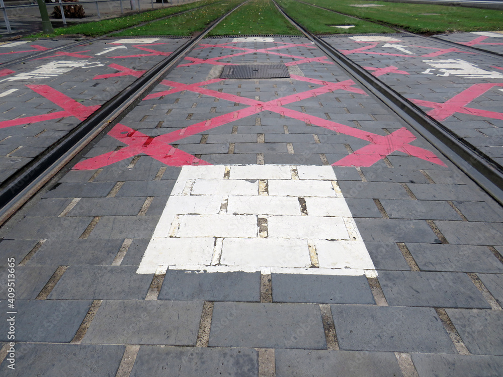 Pavement with tram passage signs. Cobbled street with tram tracks and ...
