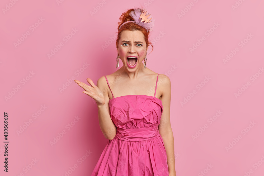 Emotional angry redhead young European woman comes on carnival raises ...