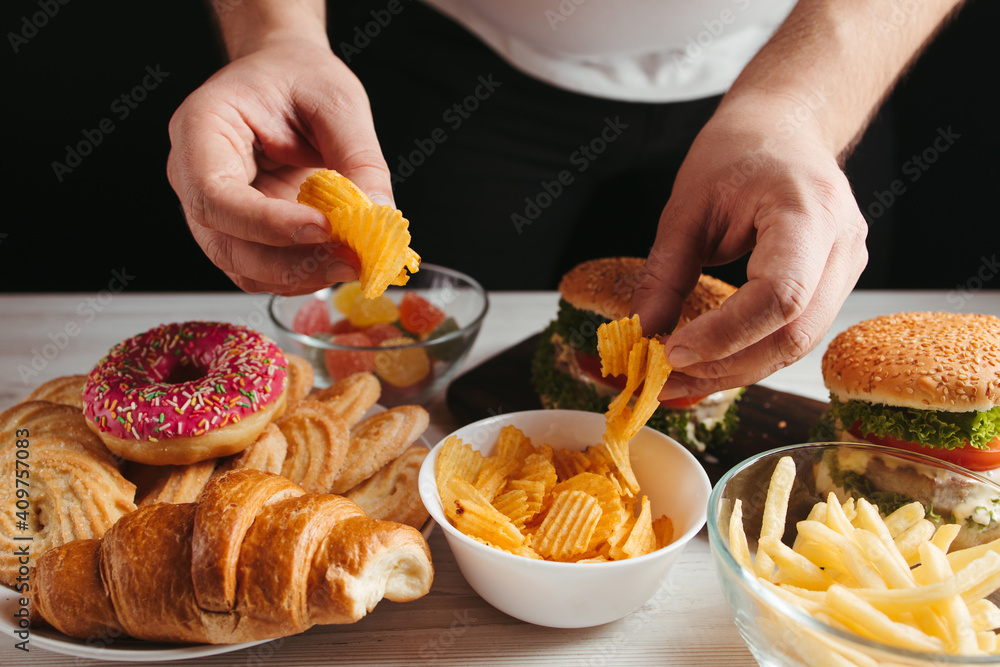 Unhealthy snack, junk food, compulsive overeating. Man overeating ...