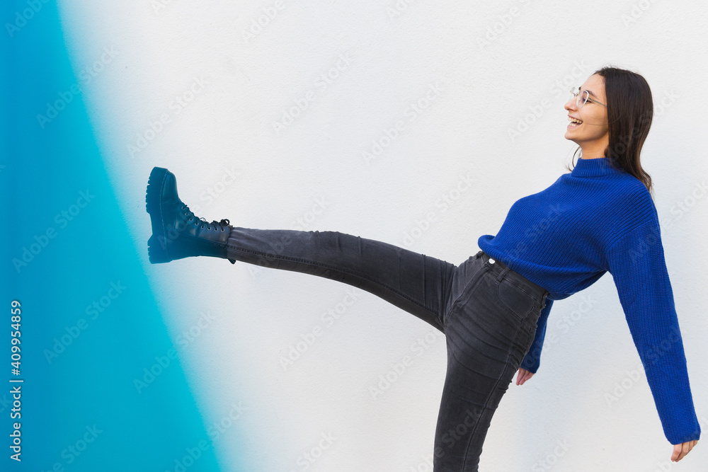 Side view of cheerful female millennial in stylish outfit standing on ...