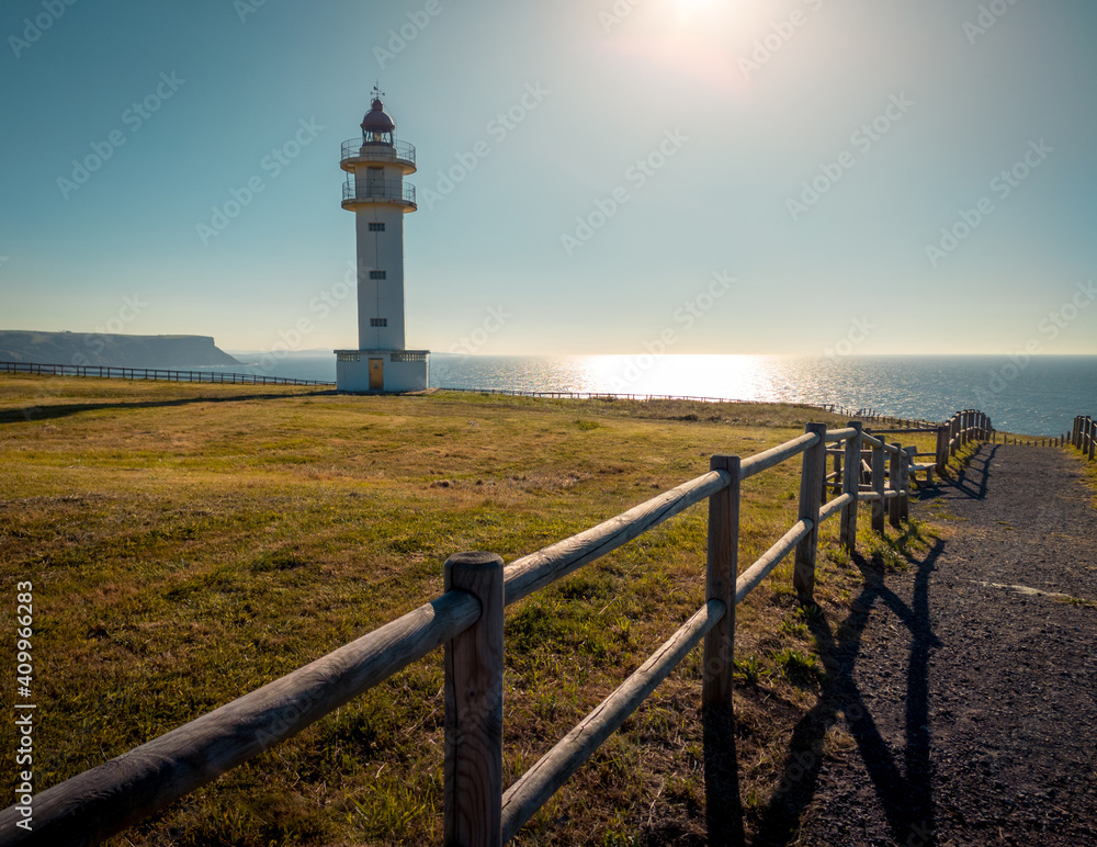 Road towards lighthouse located in front of sea in Cabo de Ajo against ...