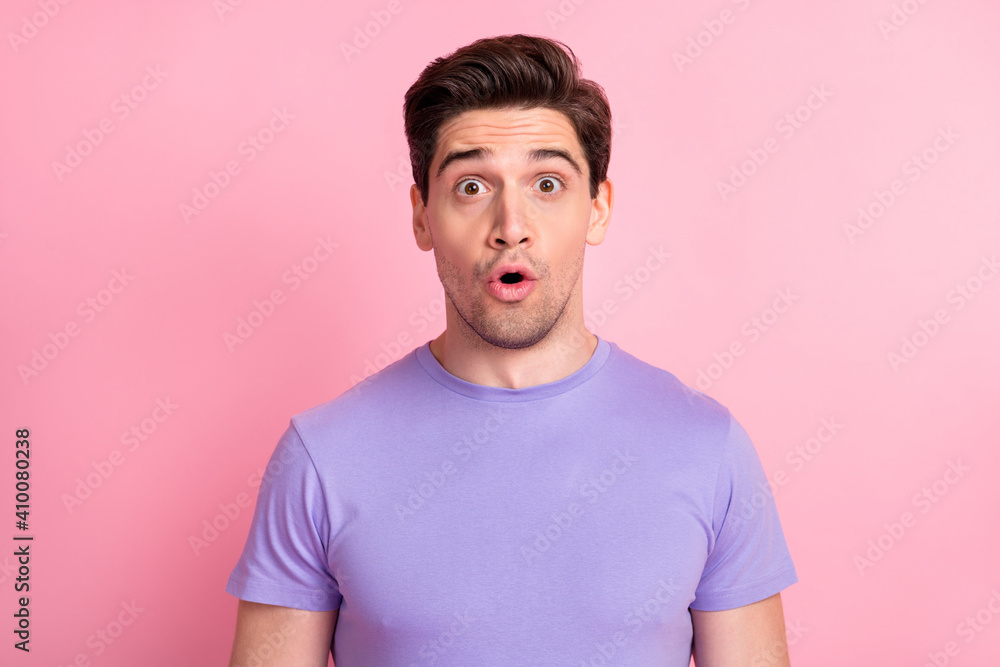 Portrait of attractive amazed guy wear violet tshirt reaction pout lips isolated over pink ...