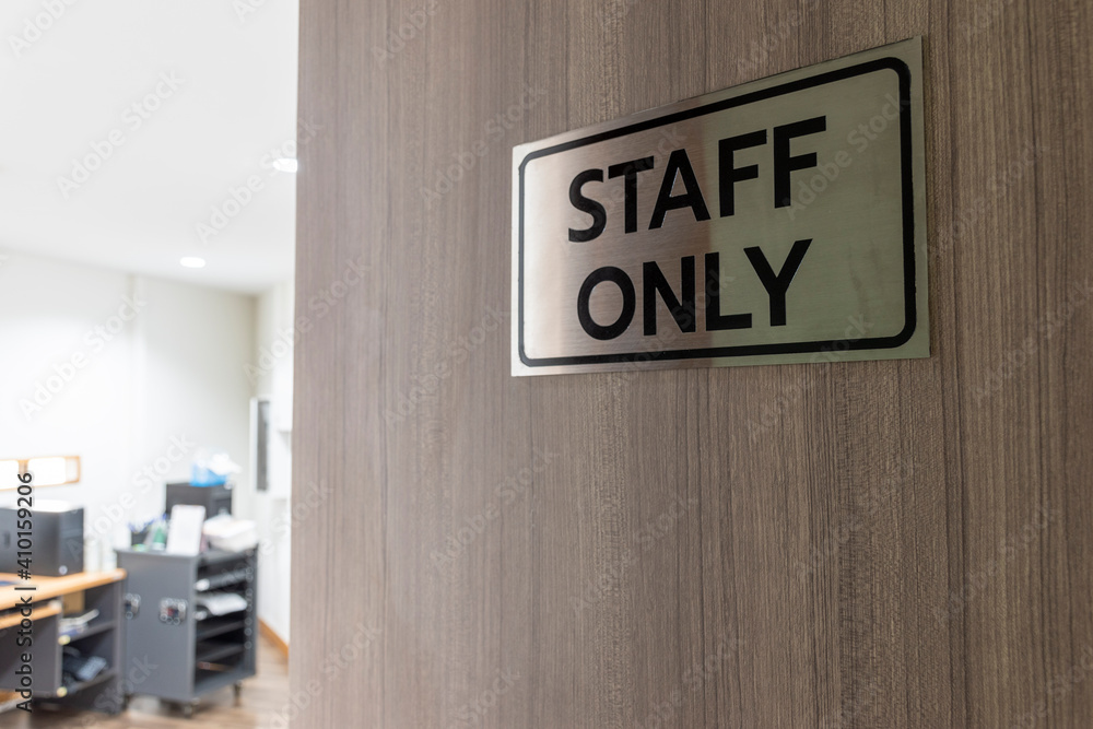 Warning sign in front of the door with a message for staff only with ...