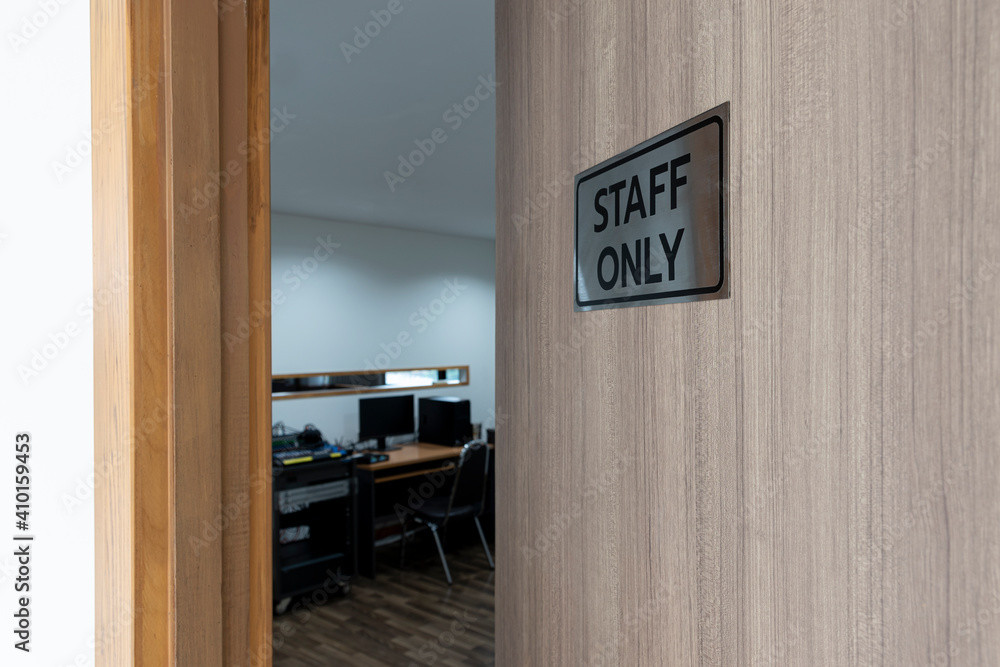 Warning sign in front of the door with a message for staff only with ...