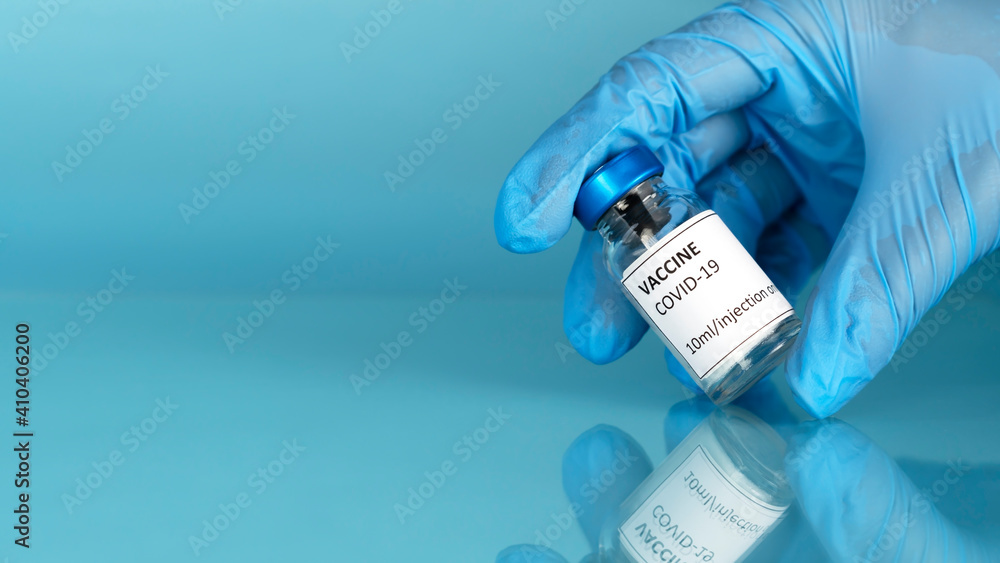 Coronavirus vaccine. The doctor's gloved hand holds vaccine ampoule in ...