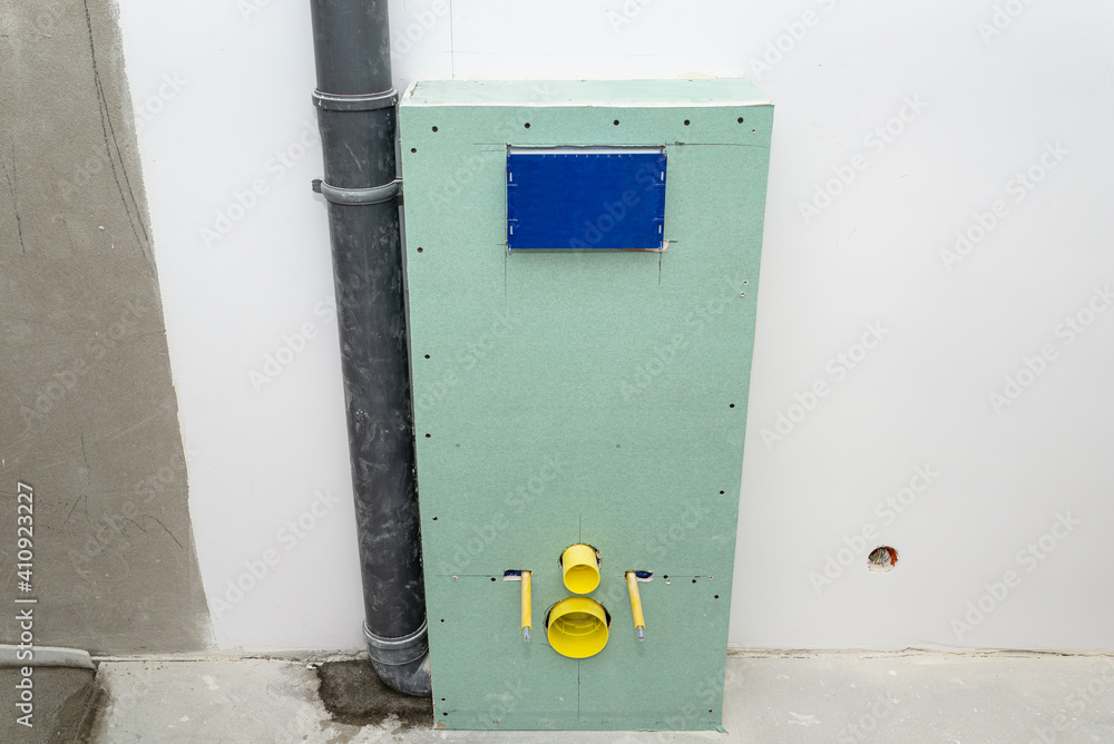 Newly installed WC concealed frame for wall-mounted toilet connected to ...