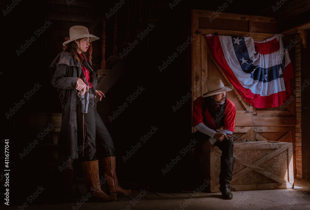 Cowgirl and cowboy posing with rifle gun on hand to show protected ...