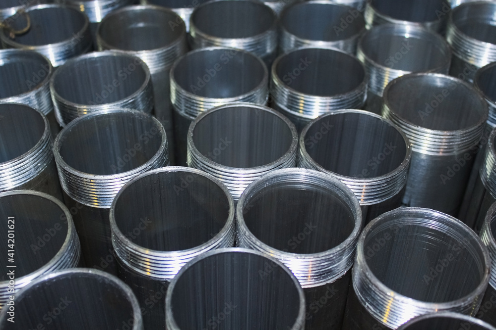 Untreated stainless steel threaded pipes in a production warehouse ...