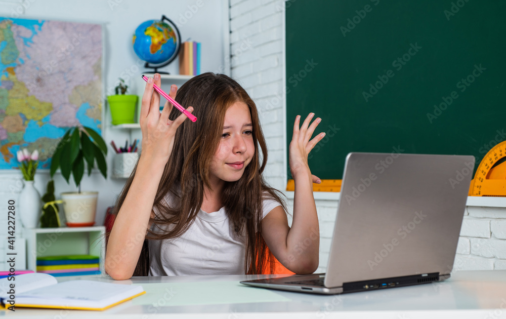 knowledge day. child pupil sit at table and use computer. girl is ...