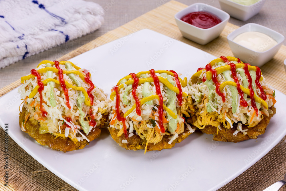 Plato de comida venezolana hecho de tostón con ensalada de col, queso ...