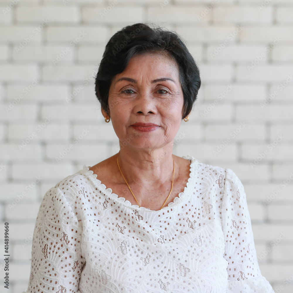 Photo Stock Head shot close up face portrait of 70 years old Asian woman looking with little ...