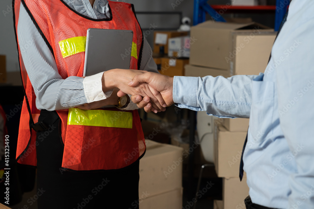 Warehouse worker handshake with manager in storehouse . Logistics ...
