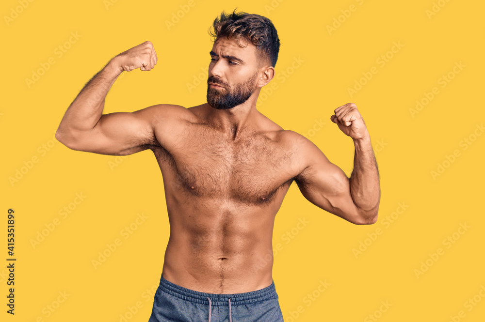 Young hispanic man wearing swimwear shirtless showing arms muscles ...