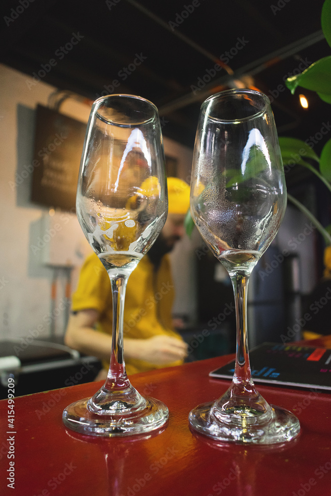 Dos copas vacías con residuos de cerveza sobre una barra, de fondo un ...