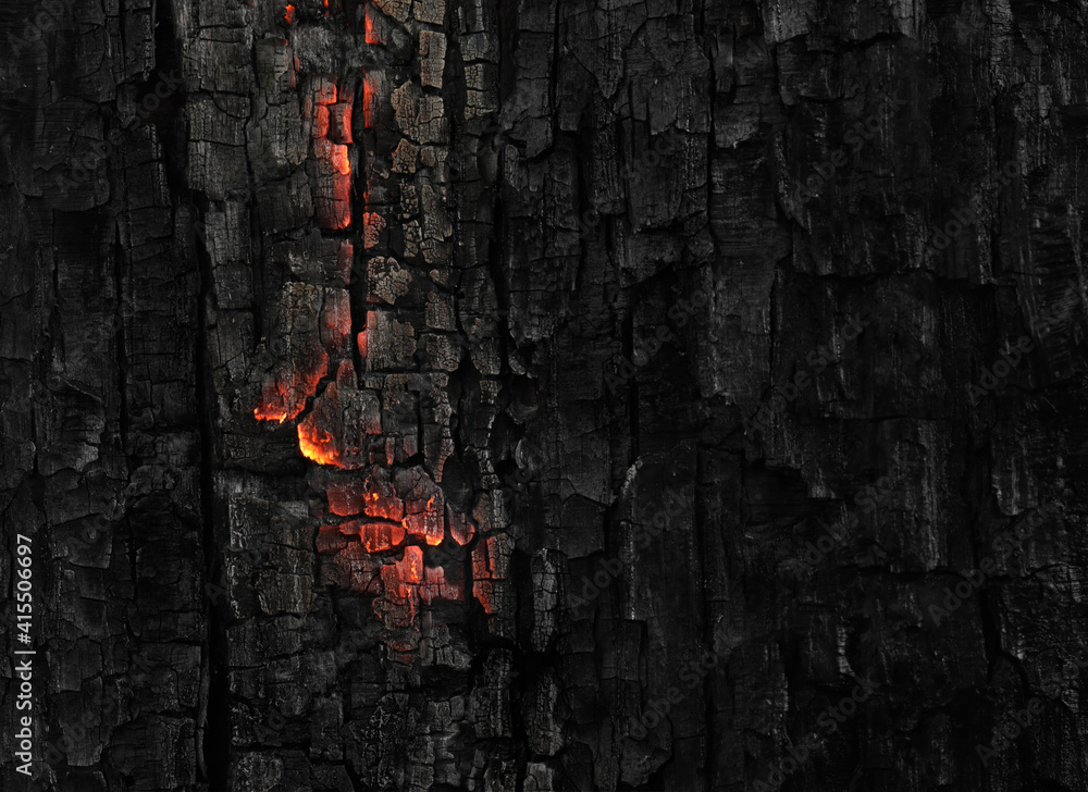 Dark black background of burnt wood with red hot embers still burning ...