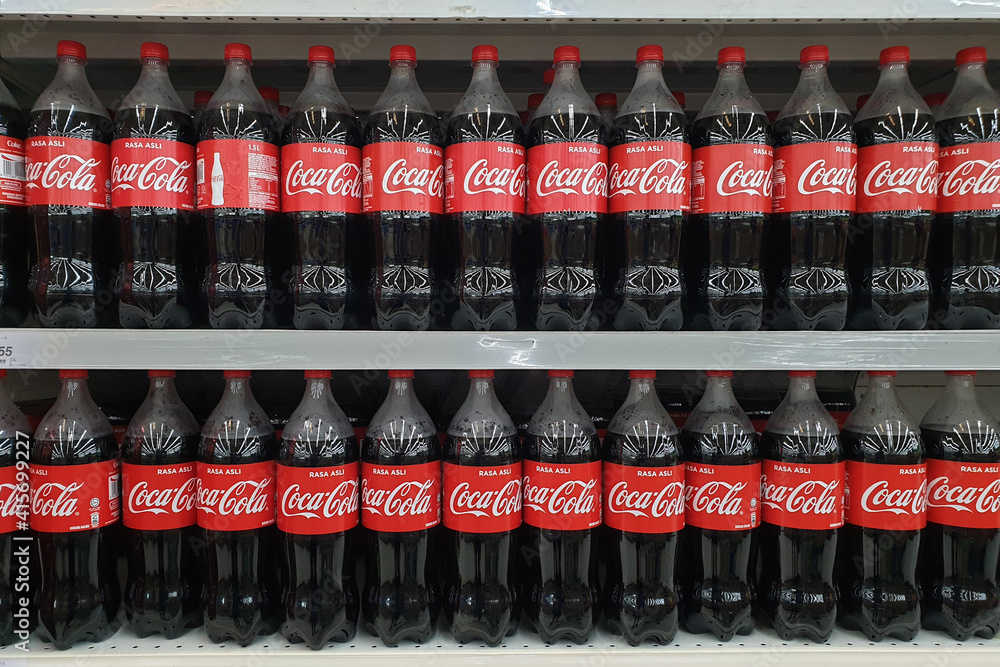 Rows of Coca-Cola bottle drink on display in a grocery store. Coca-Cola ...