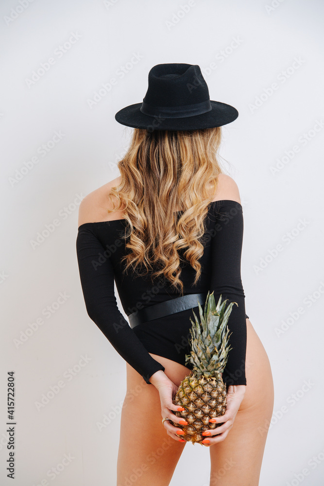 Photo Stock Beautiful woman with wher back turned posing for a photo in a long-sleeve bodysuit ...