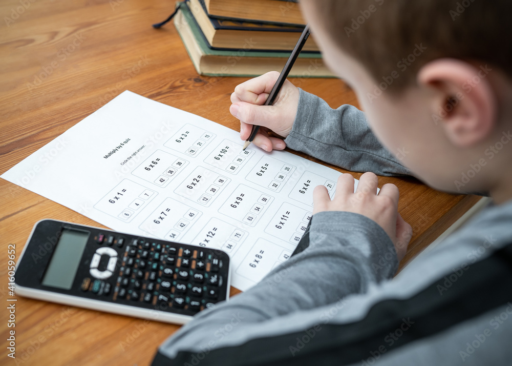 Young boy doing maths homework test times tables multiplication exam ...
