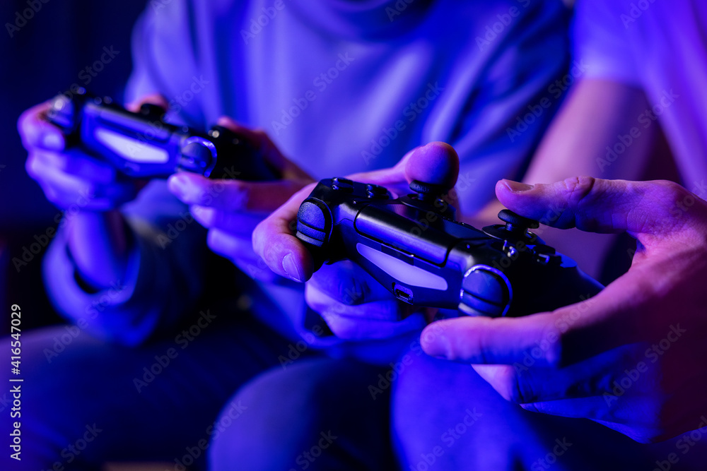 friends playing console video games. controller in hands closeup. neon ...