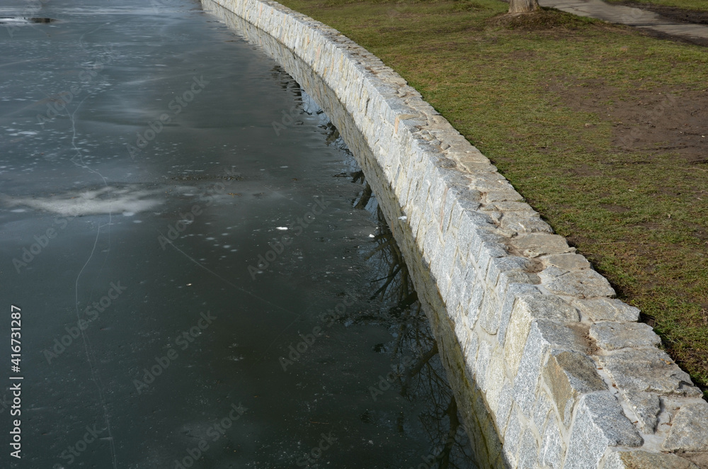 Stone retaining walls of a water reservoir or river pond dock ...