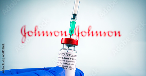 Johnson and johnson logo and covid-19 coronavaccine injection vial, sterile glass with label and ...
