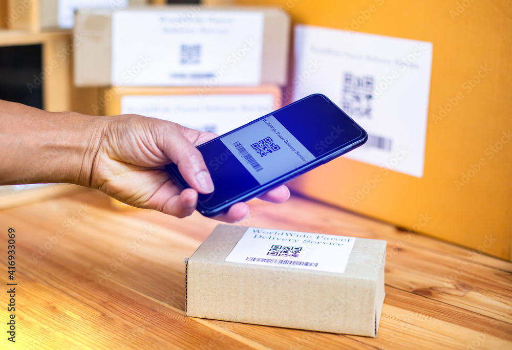Selective focus to QR code of parcel delivery tag on smartphone to scan ...