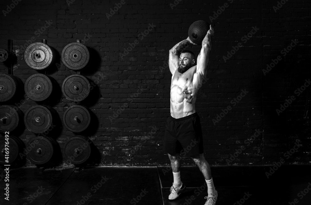 Young sweaty strong muscular fit man with big muscles doing ball ...
