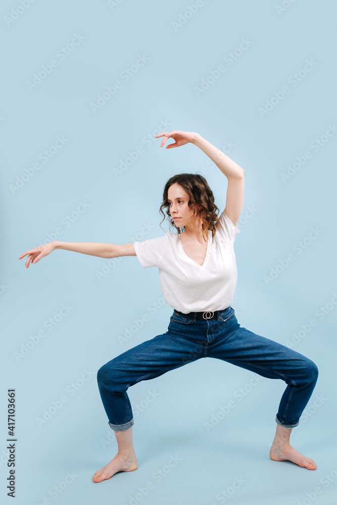 Serious contemporary dancer poses in front of blue studio background ...