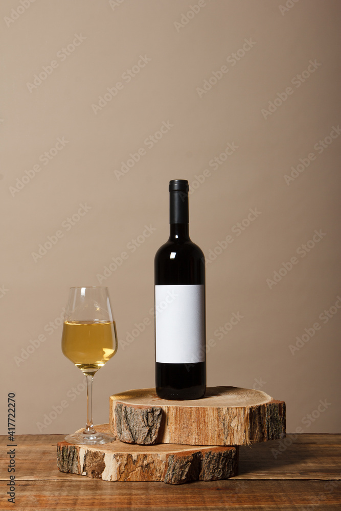 Blank white label mock up on black bottle of unlabeled wine on a wooden ...