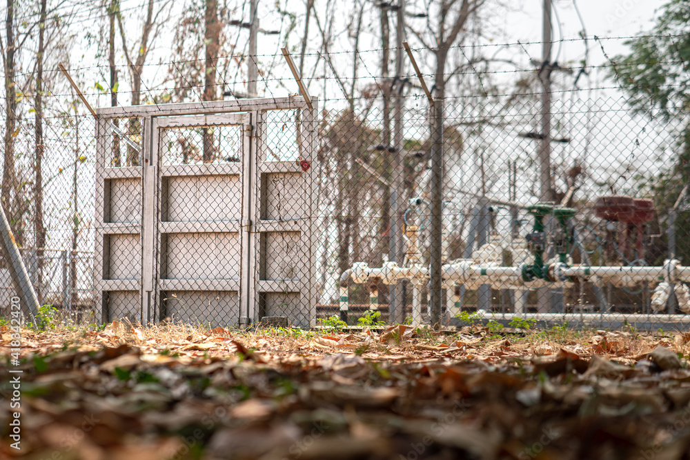 Thick metal gate with wire fence barricaded area of the crude oil ...