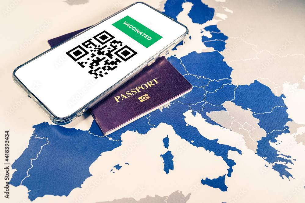 Digital green passport with QR code on a smartphone over an EU map.The ...