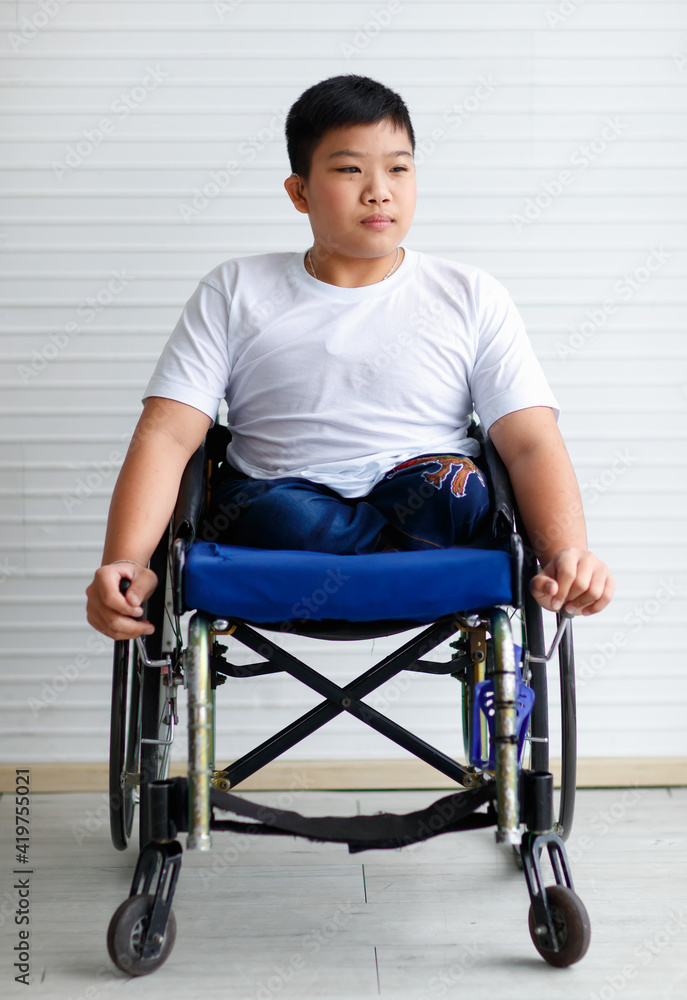 Young Asian handicapped teenage boy without legs sitting on wheel chair ...