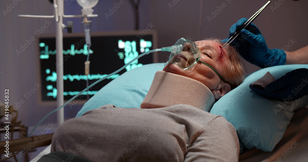 Injured woman with neck brace and oxygen mask in hospital bed, nurse ...