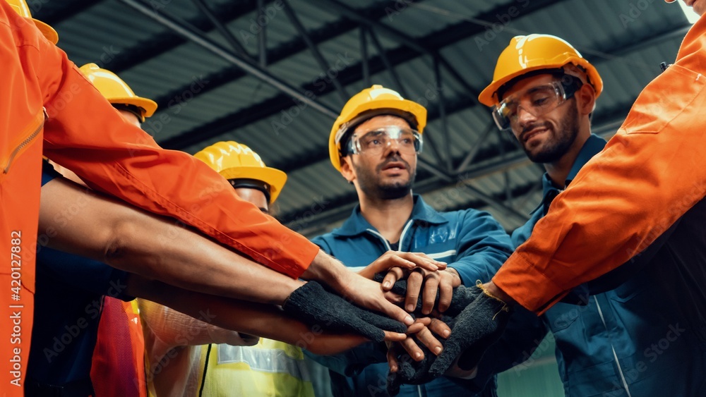 Foto Skillful worker stand together showing teamwork in the factory ...