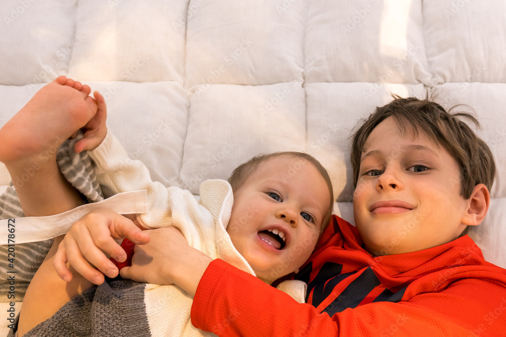 An 11 month old baby and her 8 year old brother have fun playing together. Happy family life ...