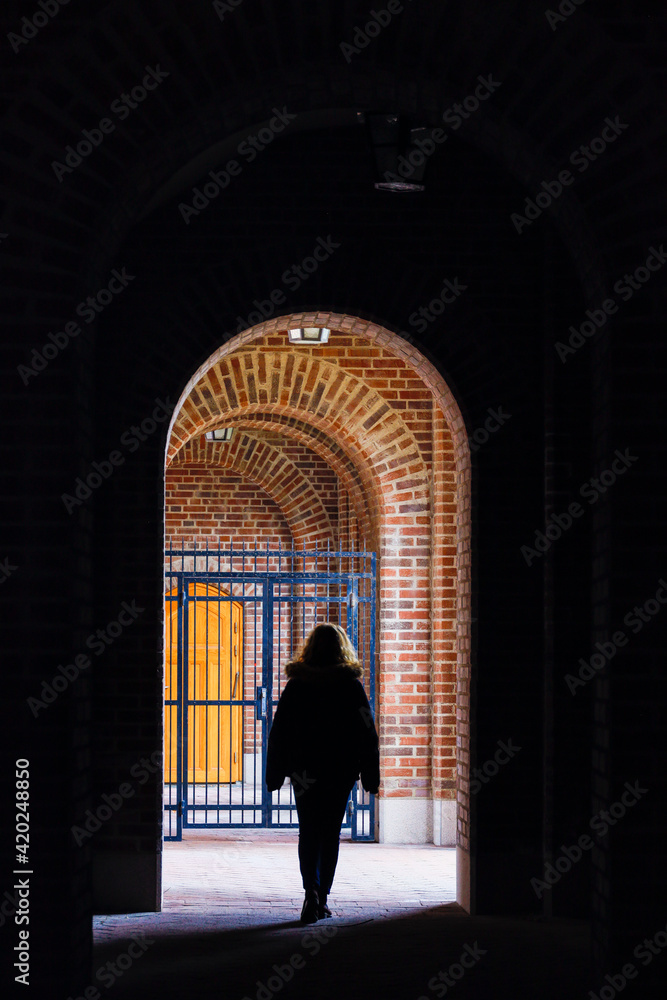 Stockholm, Sweden A woman walks under an archway in an outdoor corridor ...