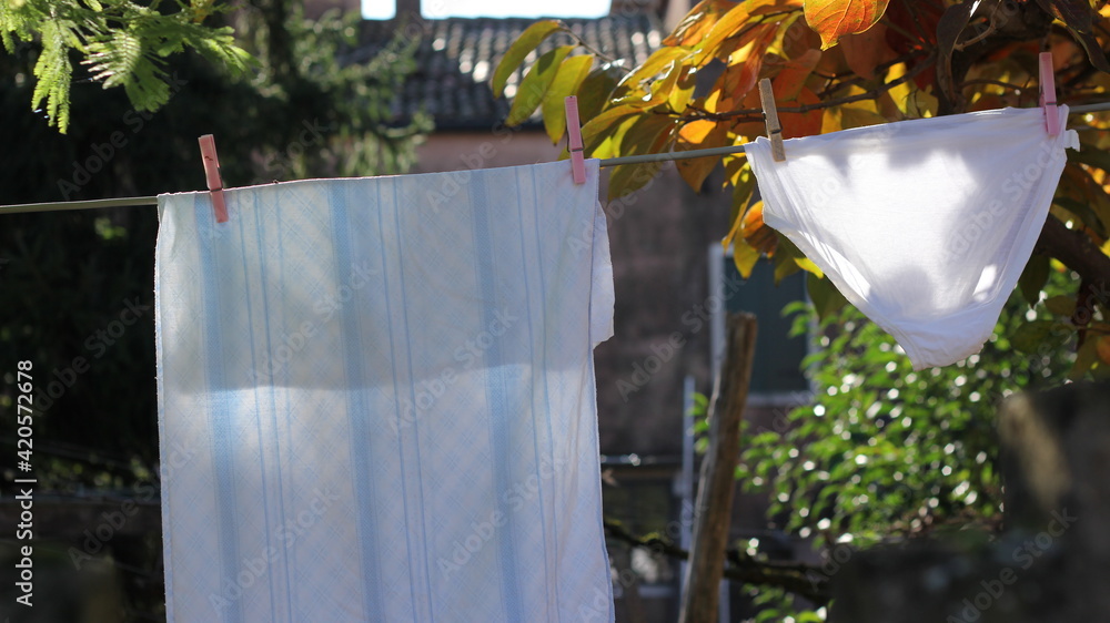 laundry suspended on a clothesline, for drying, consisting of a towel ...